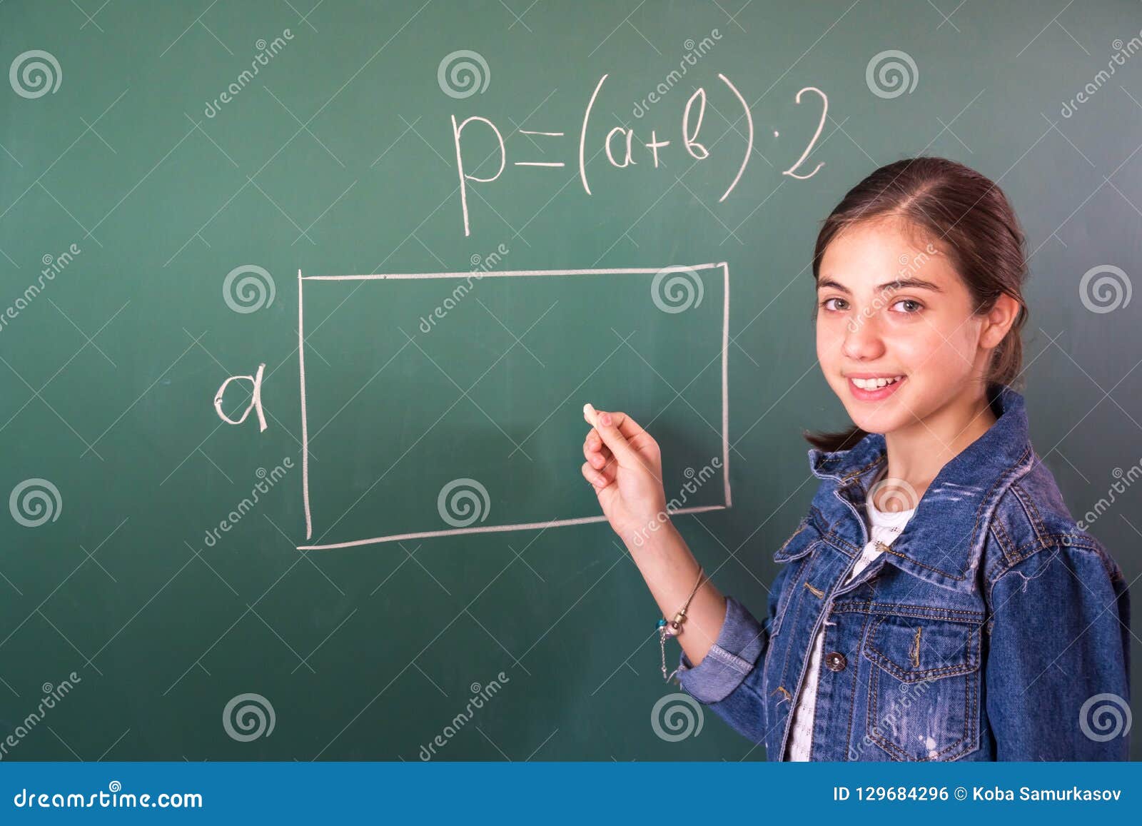 Schoolgirl With Chalk At The Blackboard Solves A Math Problem Stock ...