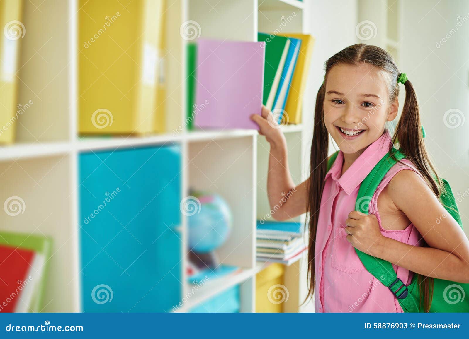 Schoolgirl in library stock image. Image of backpack - 58876903