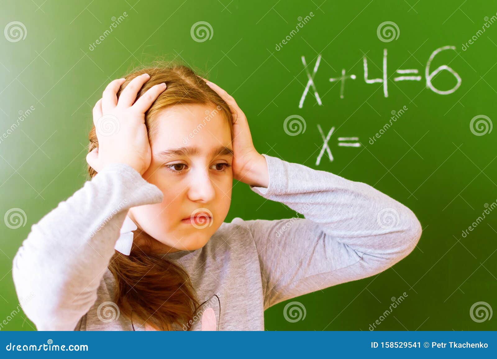 Schoolgirl Solves a Math Problem on the Blackboard during the Lesson ...