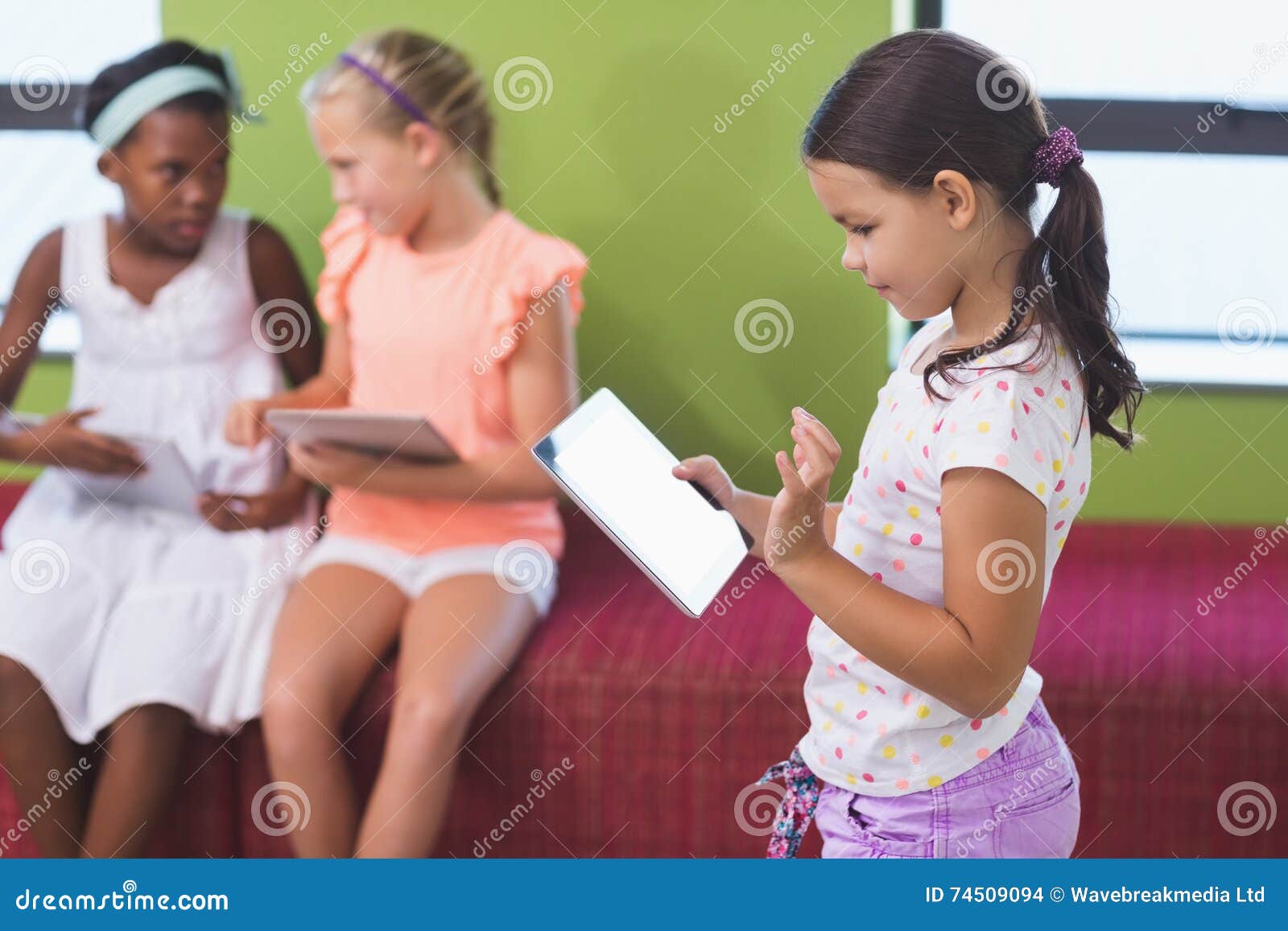 Schoolgirl Using Digital Tablet in Library Stock Photo - Image of ...