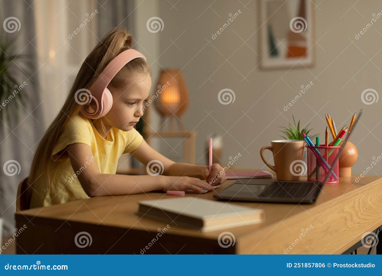 Schoolgirl Using Laptop and Taking Notes Doing Homework at Home Stock ...
