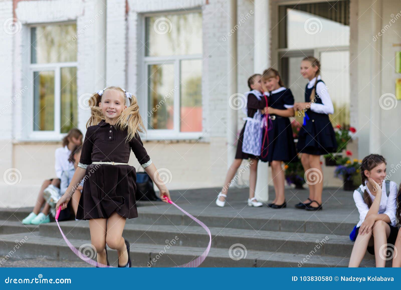 Schoolgirls Jump on a Rope at a Change in Front of the School Stock ...
