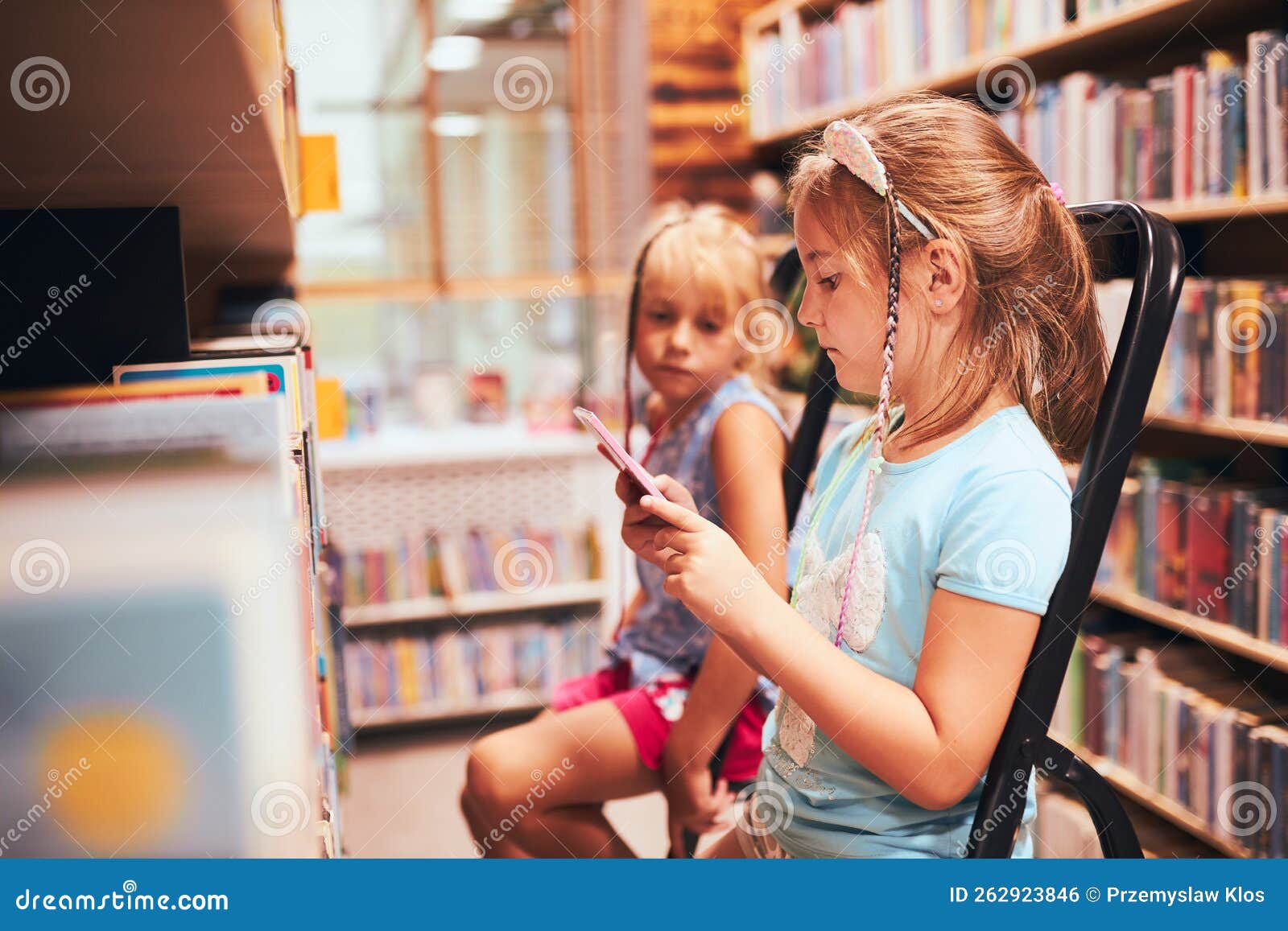 Schoolgirls Looking for Books in School Library. Students Choosing Set ...