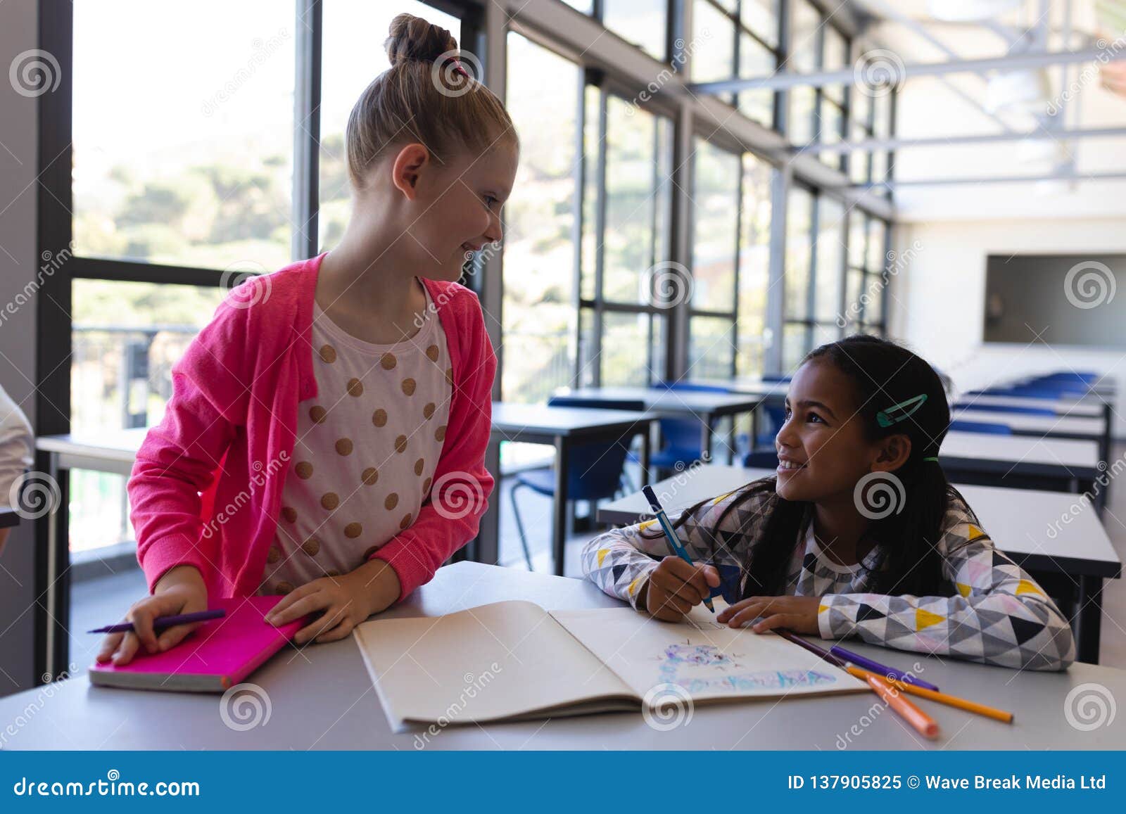 Schoolkids Talking with Each Other at Desk in Classroom Stock Image ...