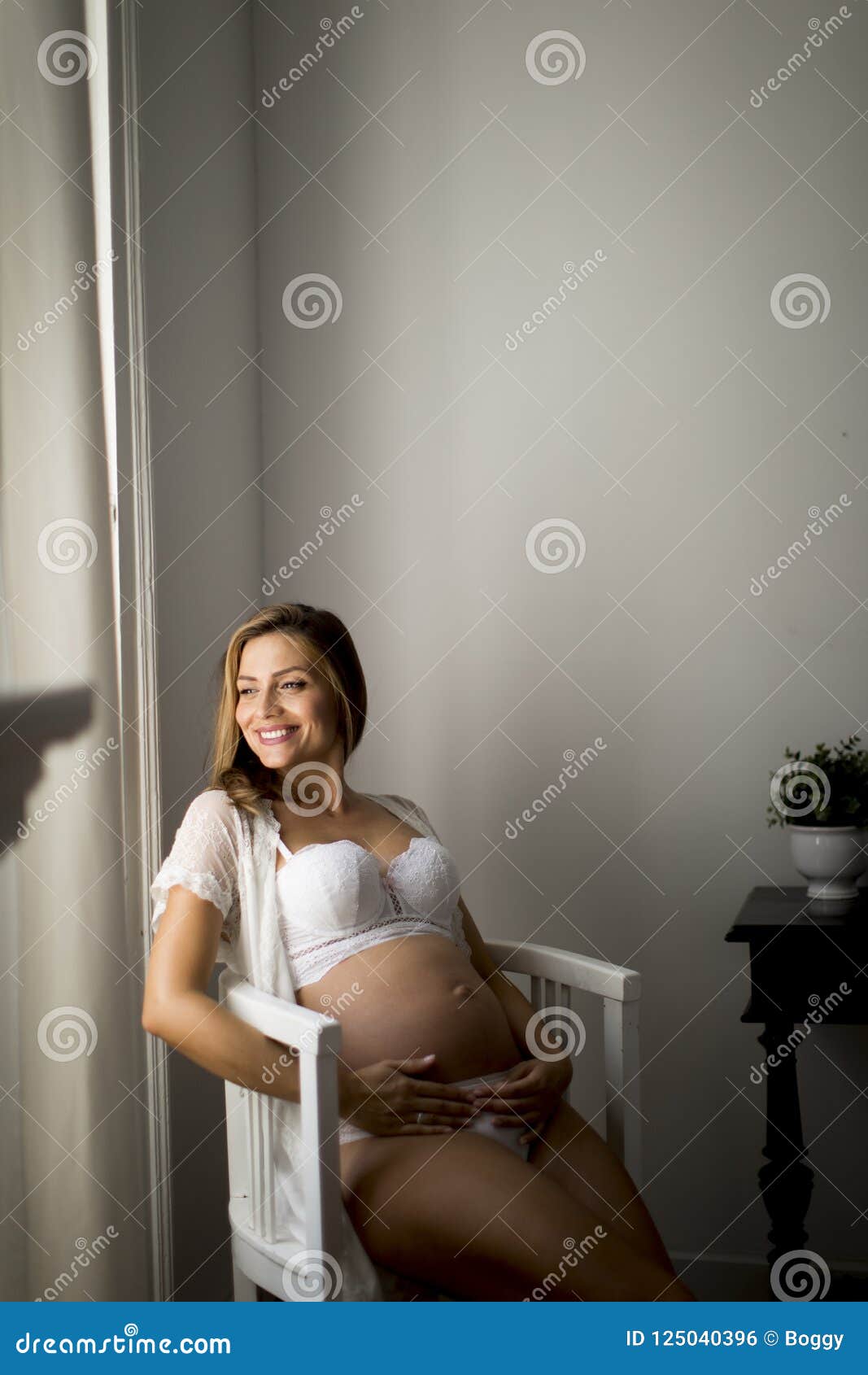 Schwangere Frau Der Junge Die Im Stuhl Sitzt Stockfoto Bild Von