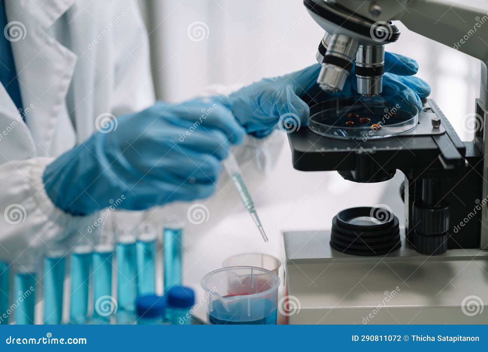 Science and Medicine, Scientist Analyzing and Dropping a Sample into a ...