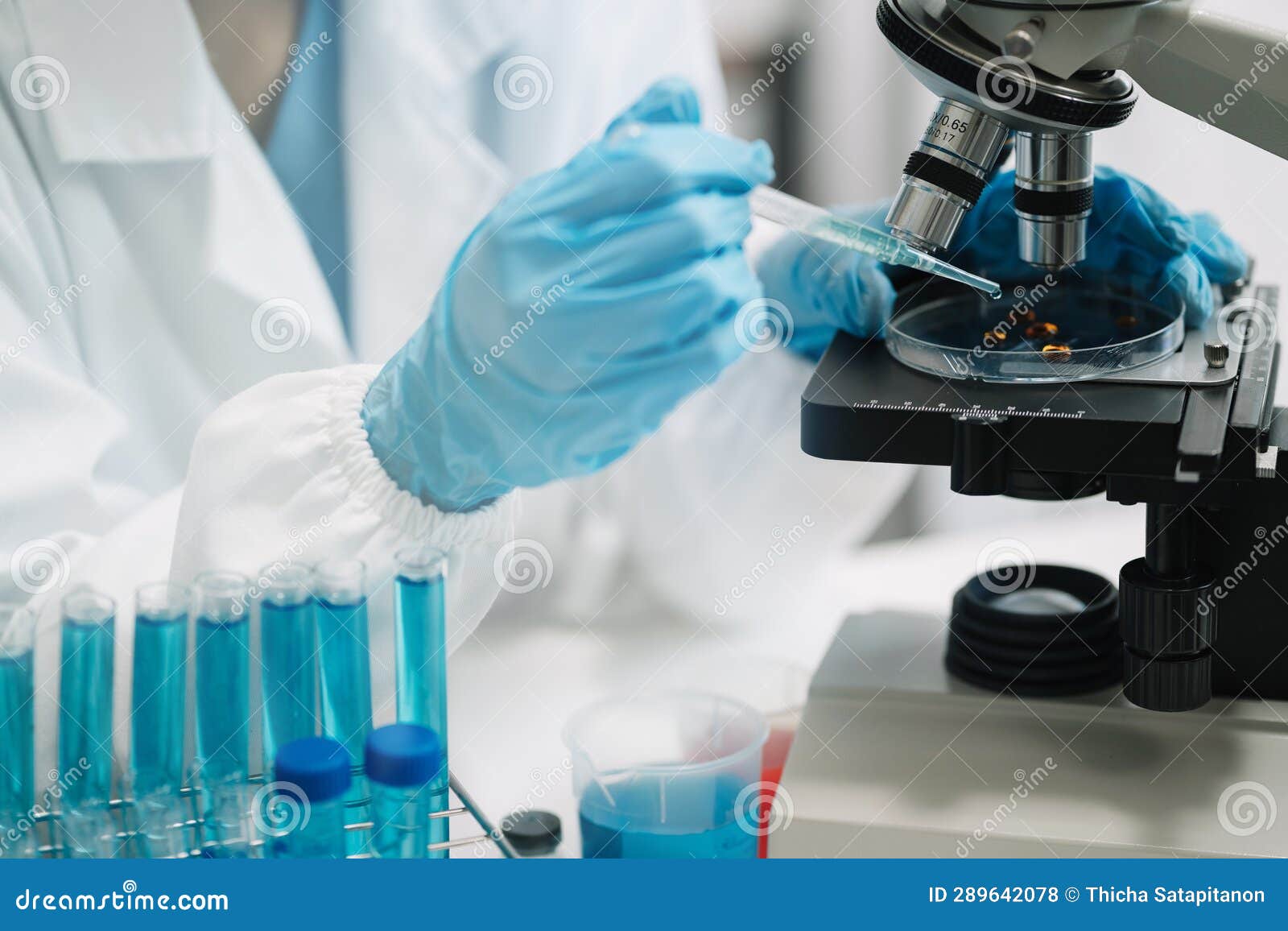 Science and Medicine, Scientist Analyzing and Dropping a Sample into a ...