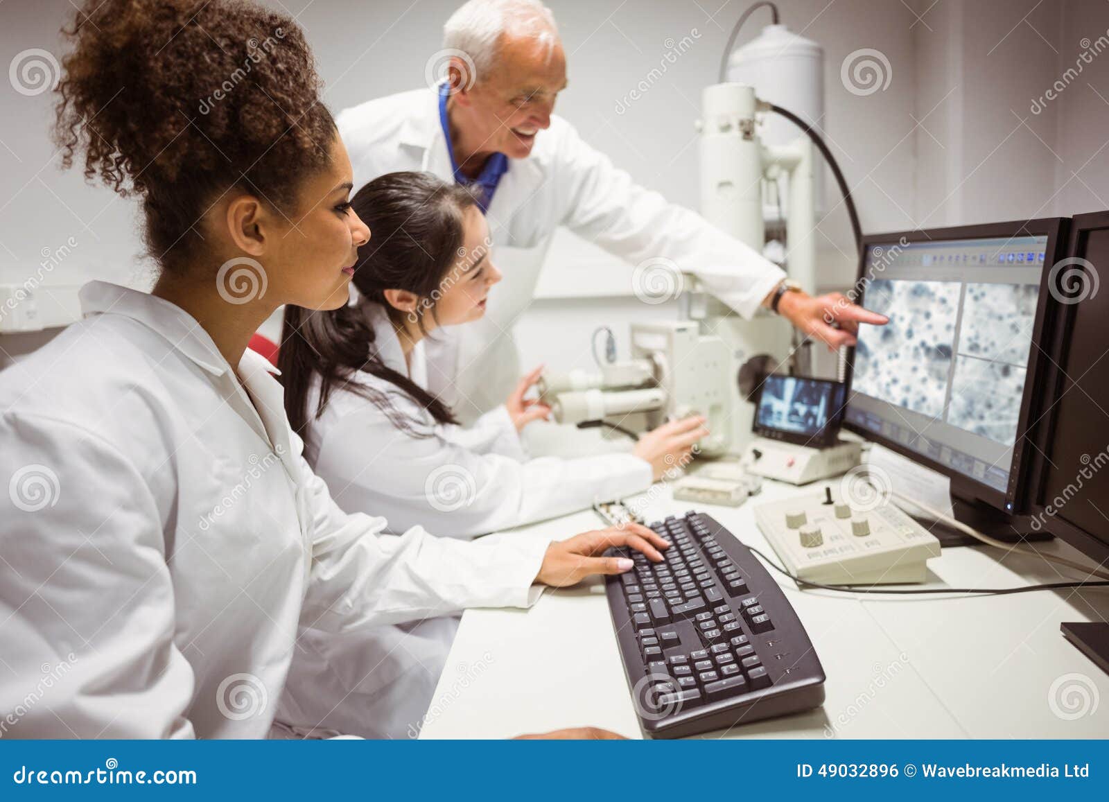 Science Students Looking at Microscopic Image on Computer with Lecturer ...