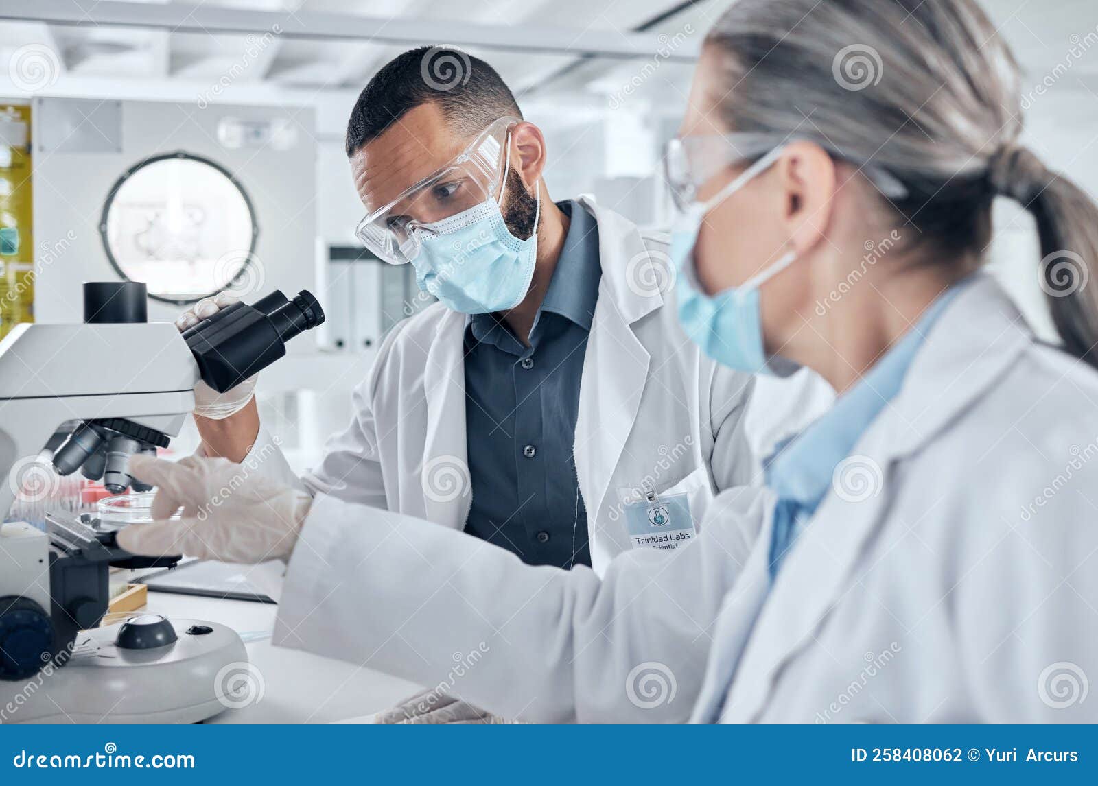 Science, Teamwork and Research with a Lab Partner Using Microscope. Man ...