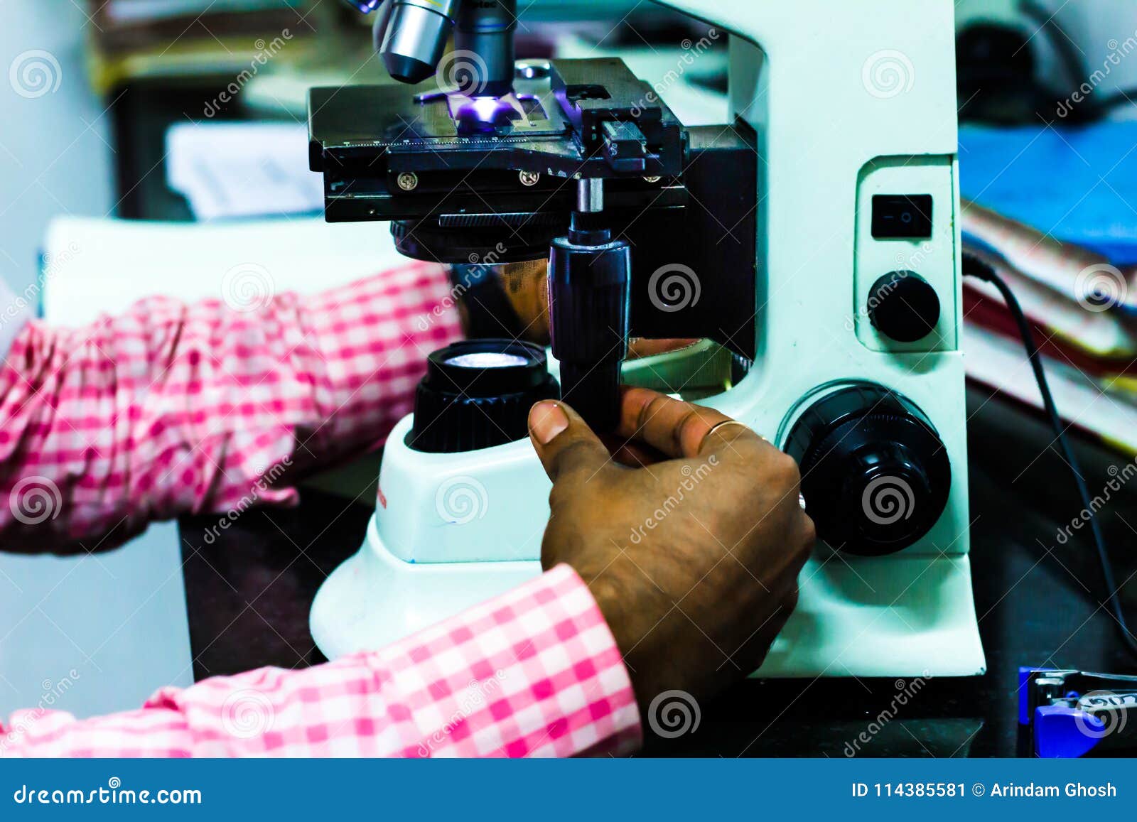 Scientist Adjusting Knobs of a Light Microscope Stock Image - Image of ...
