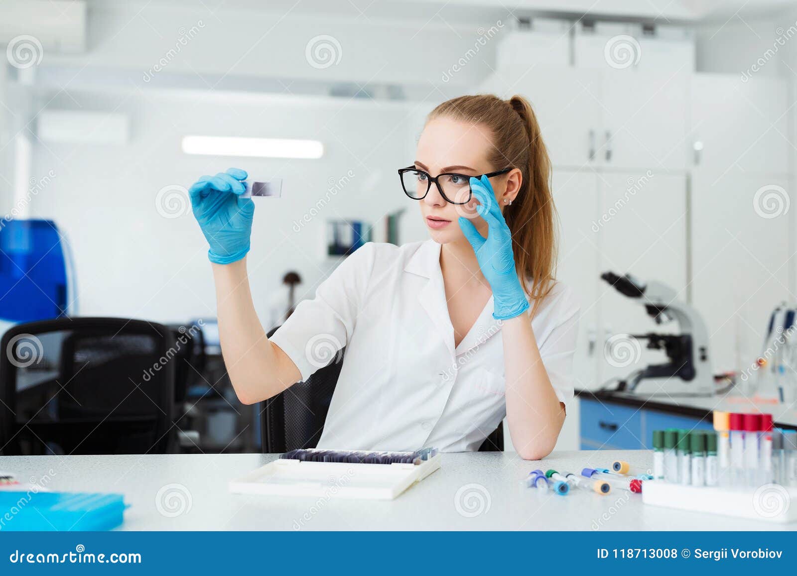 Scientist Analyzing Microscope Slide at Laboratory. Female Working in ...