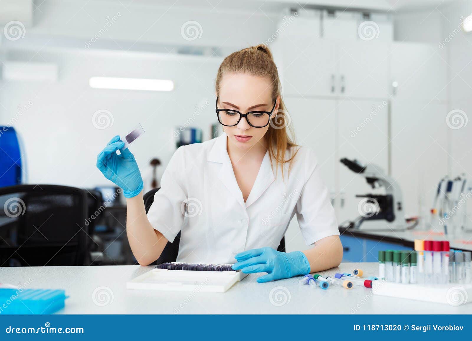 Scientist Analyzing Microscope Slide at Laboratory. Female Working in ...