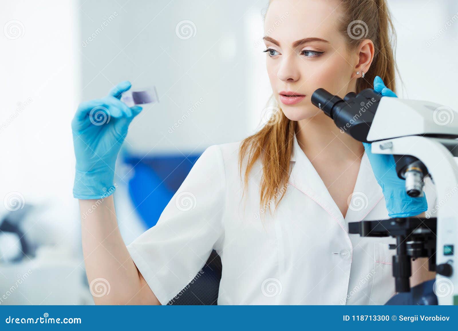Scientist Analyzing Microscope Slide at Laboratory. Female Working in ...