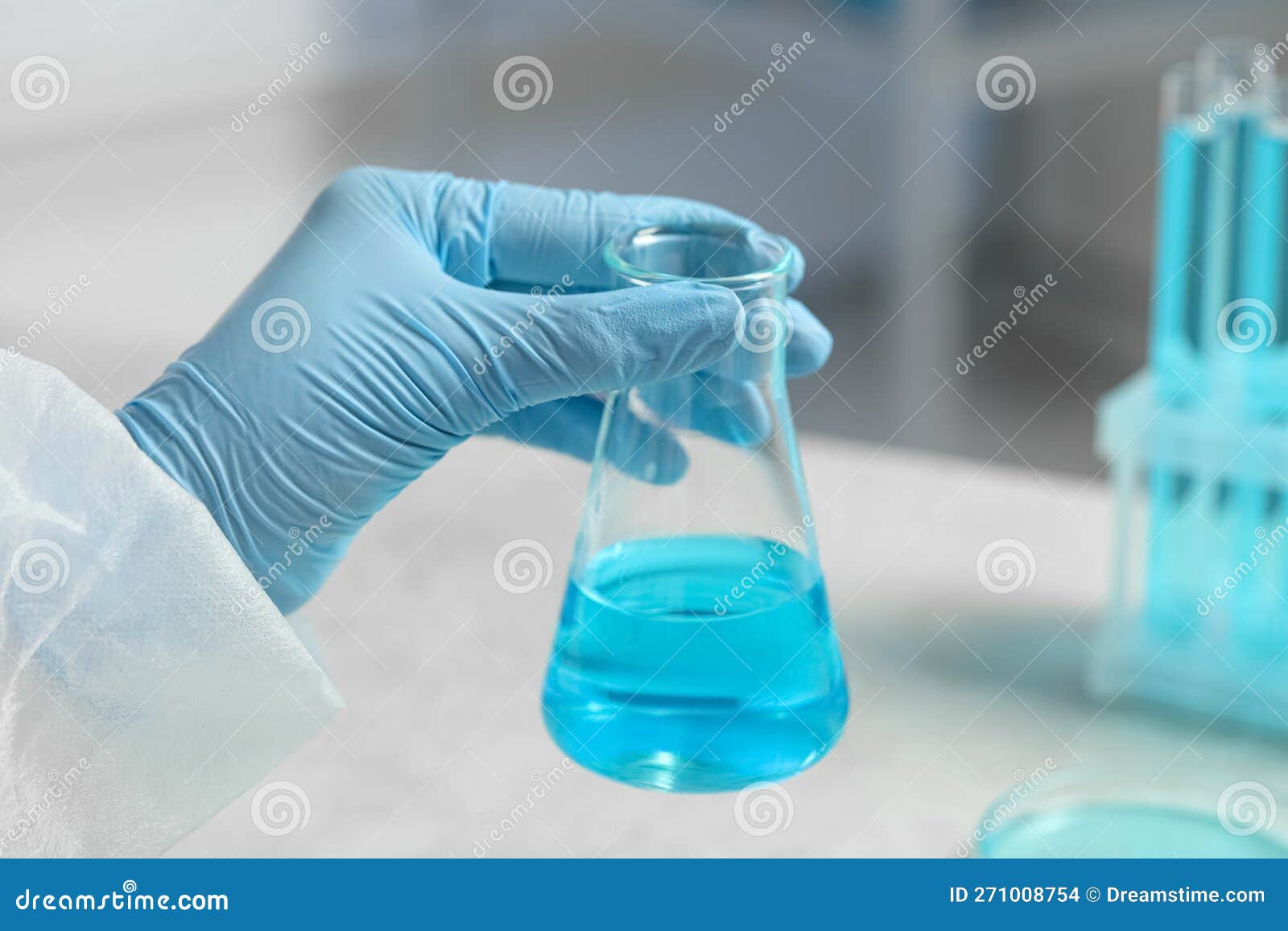 Scientist with Beaker of Light Blue Liquid in Laboratory, Closeup Stock ...