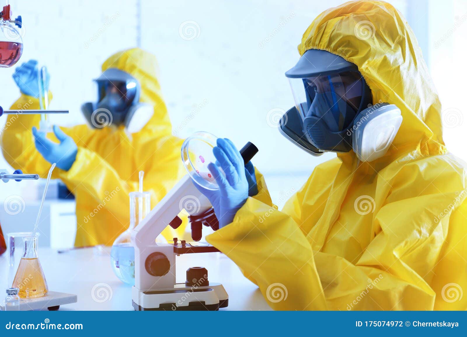 Scientist in Chemical Protective Suit Using Microscope at Laboratory ...