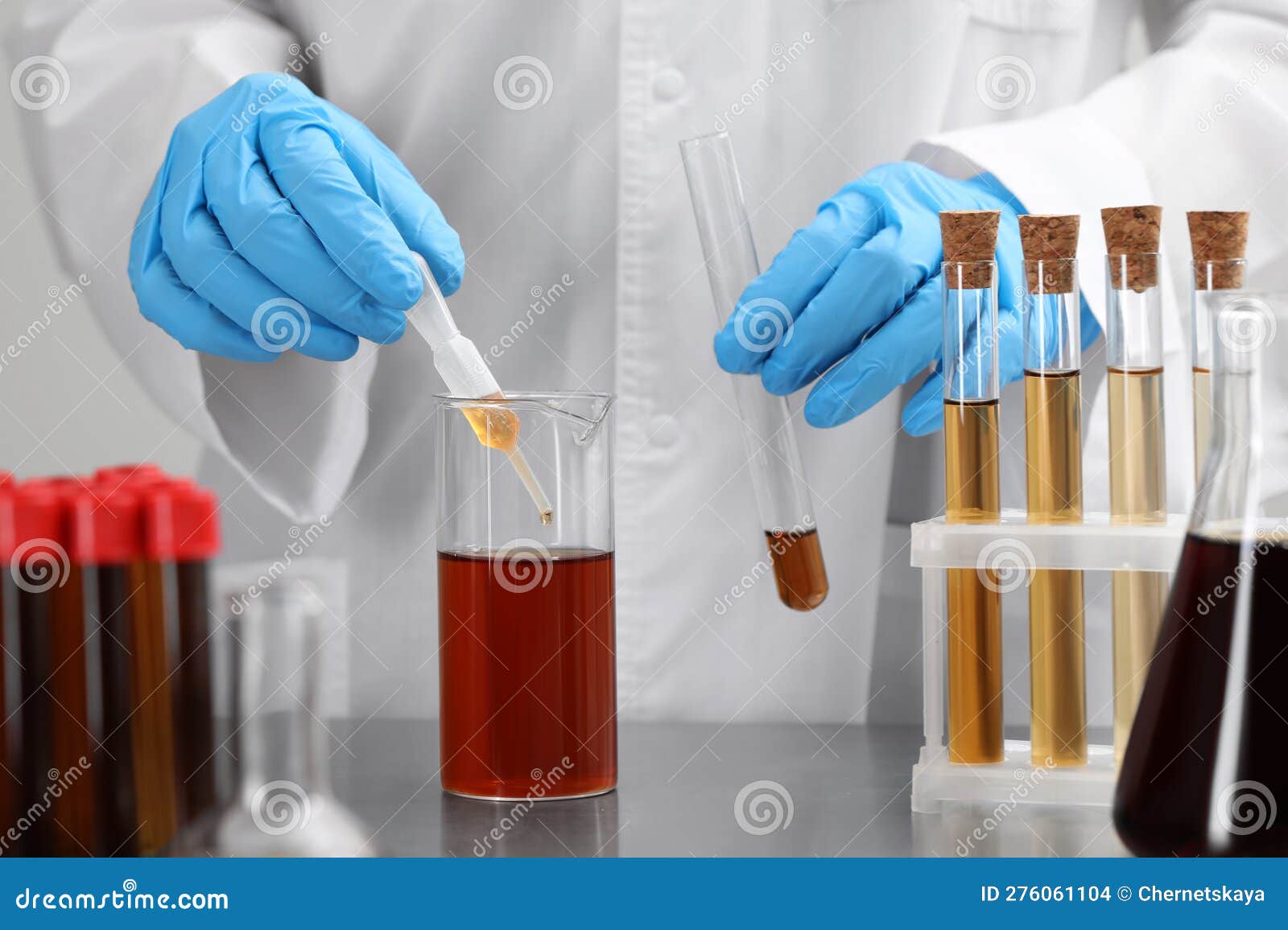 Scientist Dripping Brown Liquid from Pipette into Beaker at Table ...