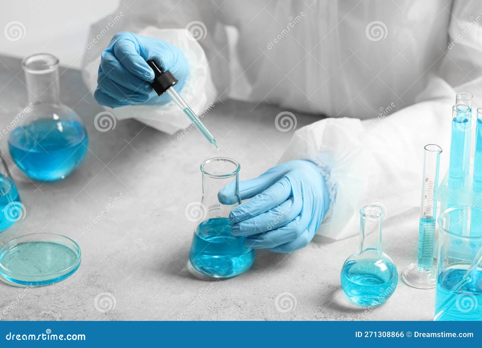 Scientist Dripping Liquid from Pipette into Beaker at White Table ...