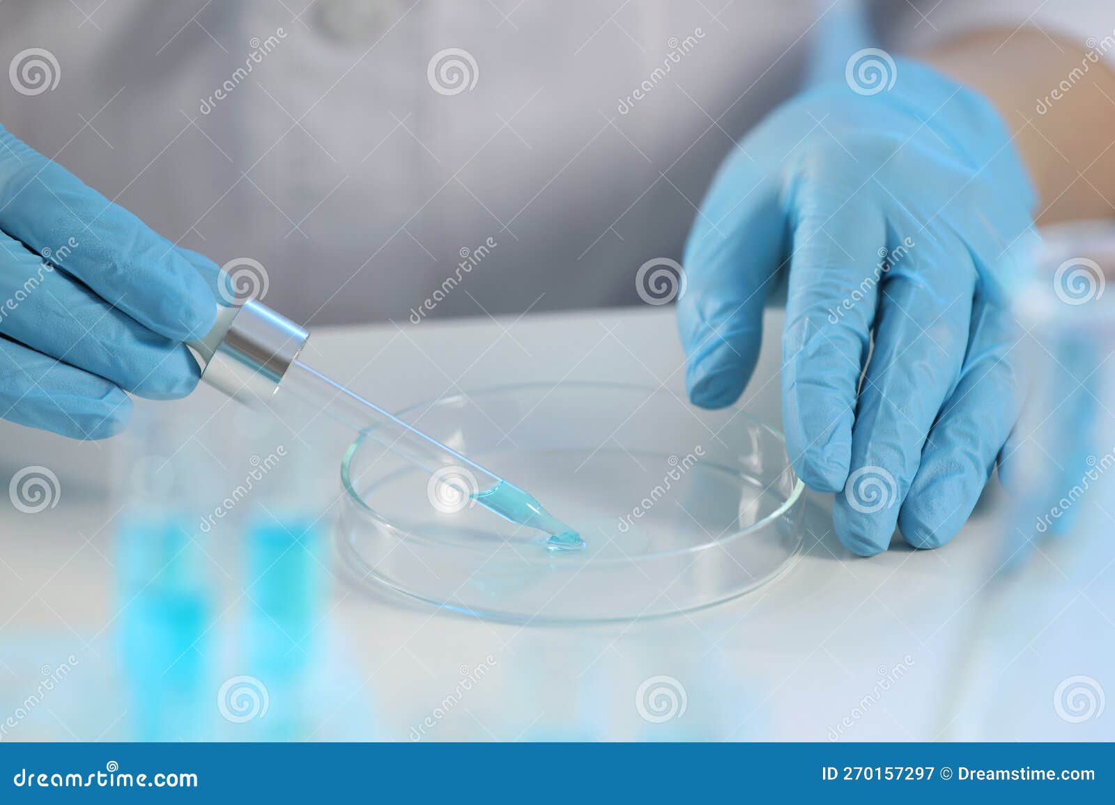 Scientist Dripping Liquid from Pipette into Petri Dish at Table ...