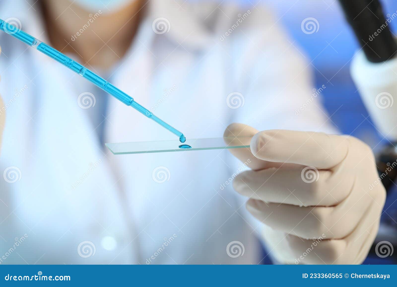 Scientist Dripping Sample of Light Blue Liquid Onto Microscope Slide in ...