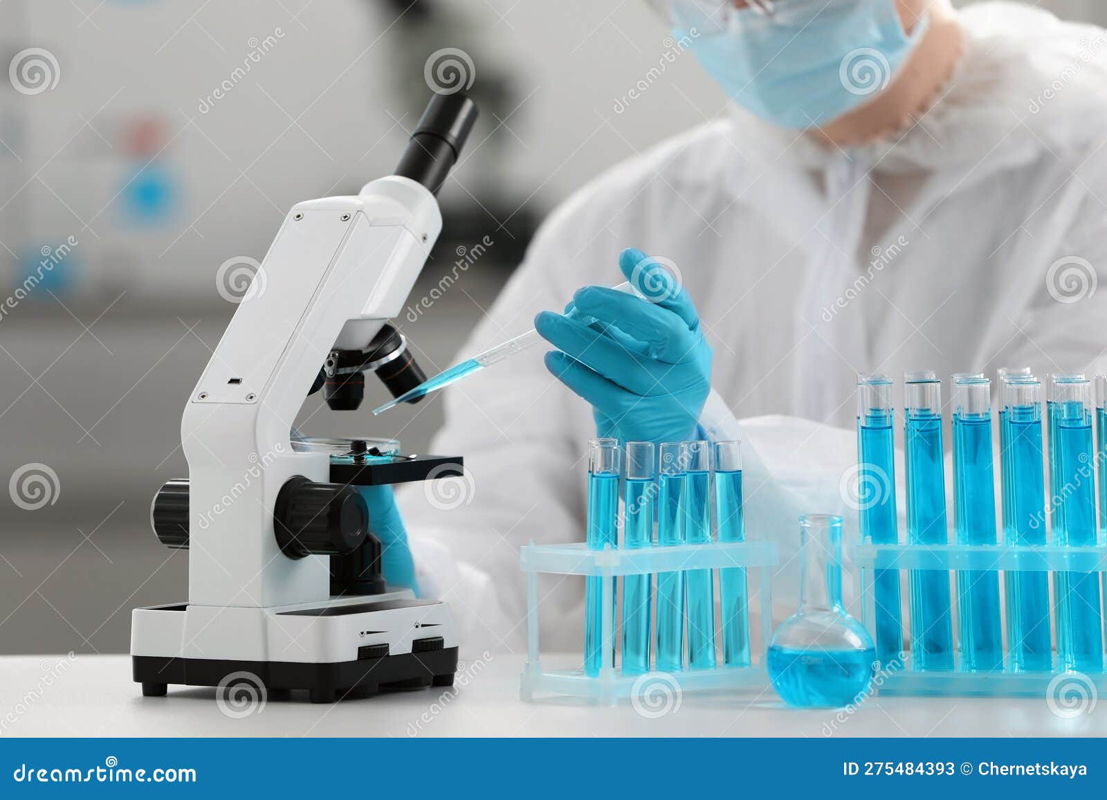 Scientist Dripping Sample Onto Petri Dish while Working with Microscope ...