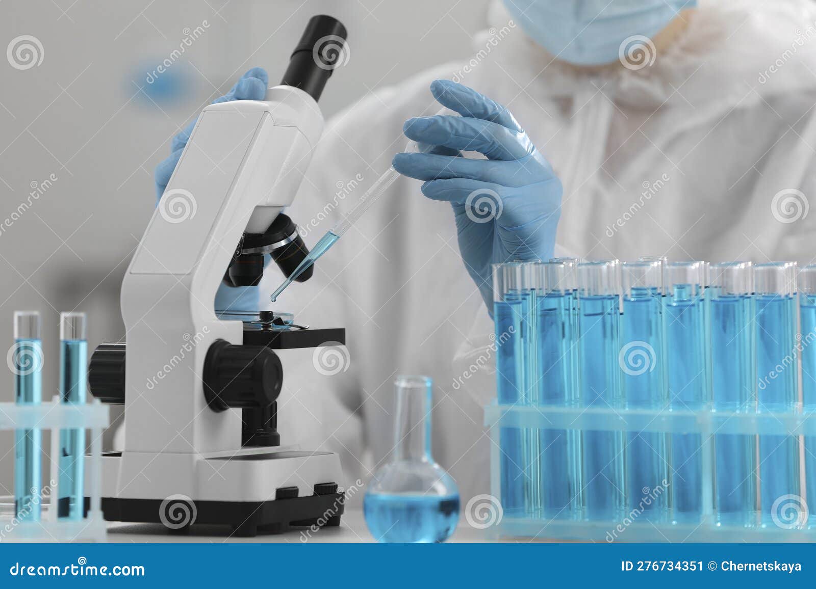 Scientist Dripping Sample Onto Petri Dish while Working with Microscope ...