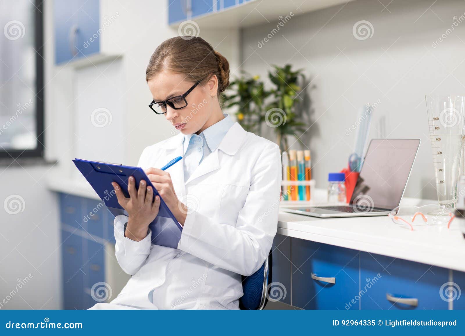 Scientist in Eyeglasses Writing in Clipboard in Research Laboratory ...
