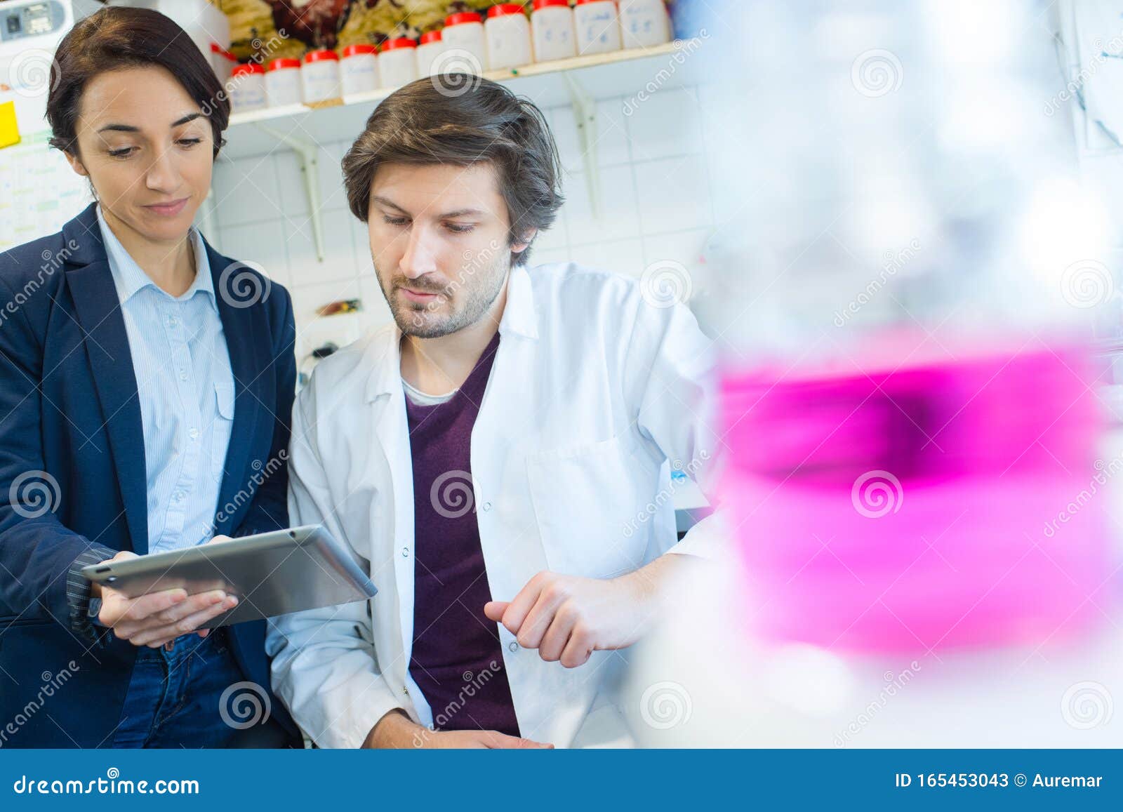 Scientist and Male Supervisor Checking Experiment Protocol at Tablet ...
