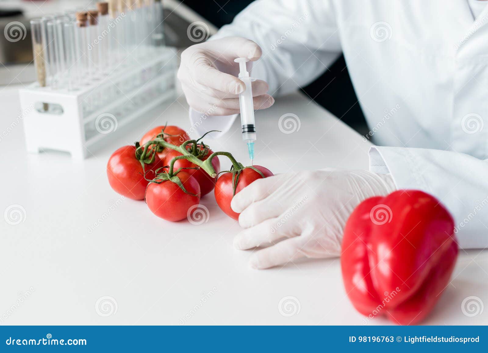 Scientist Holding Syringe and Making Experiment with Vegetables in Lab ...