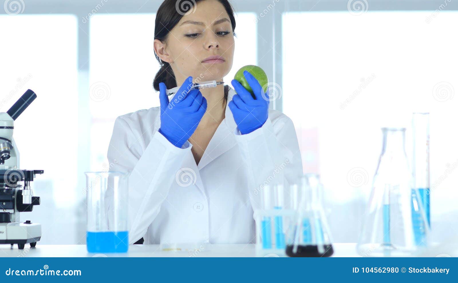 Scientist Injecting Apple with Solution for Experiment in Laboratory ...