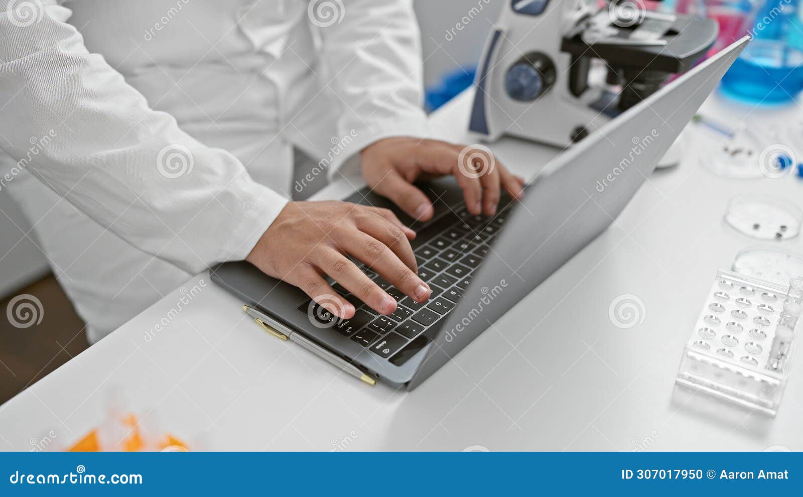 Scientist in Lab Coat Using Laptop in Laboratory with Microscope and ...