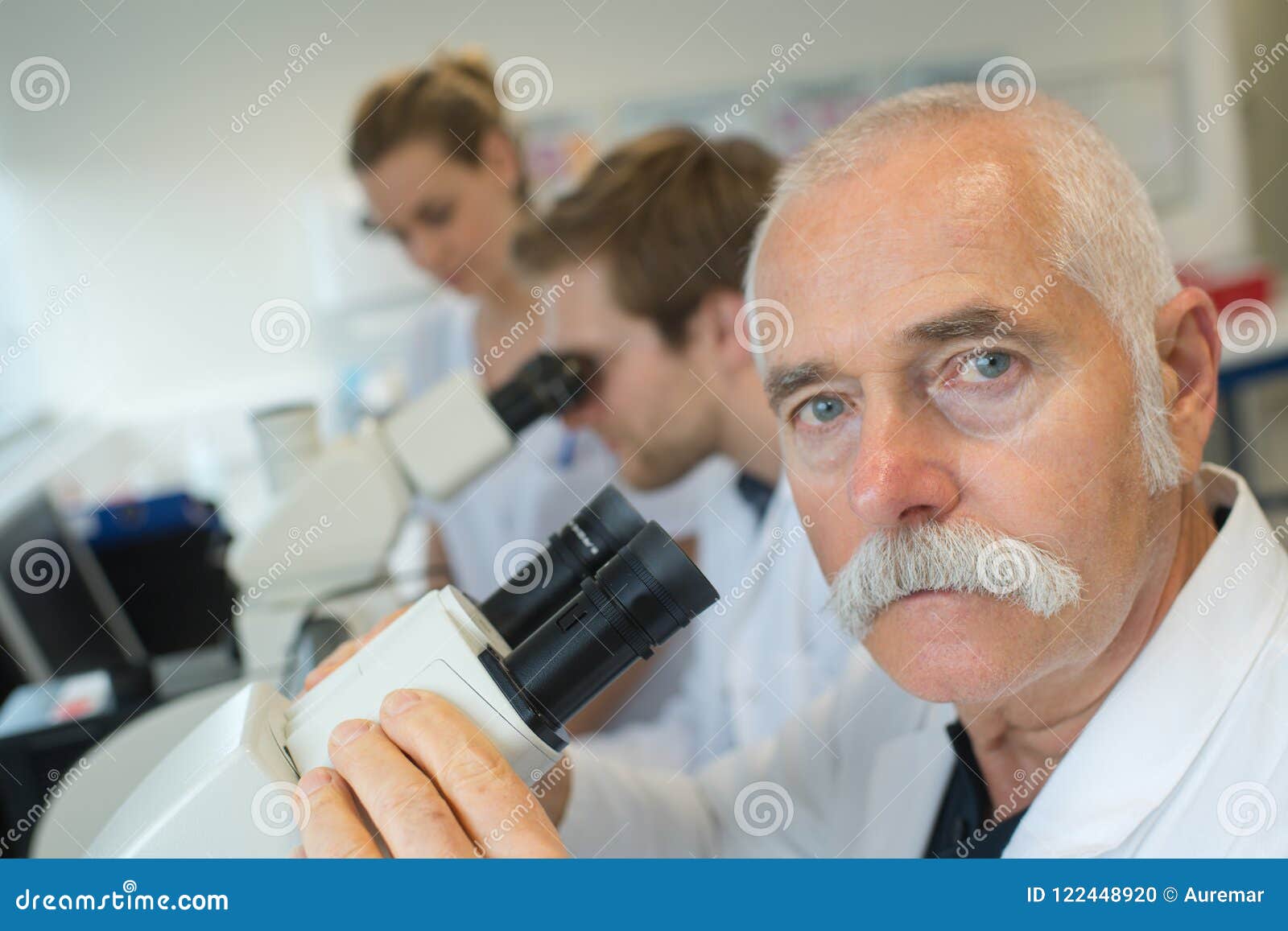 Scientist in Lab Looking through Microscope Lens Stock Photo - Image of ...