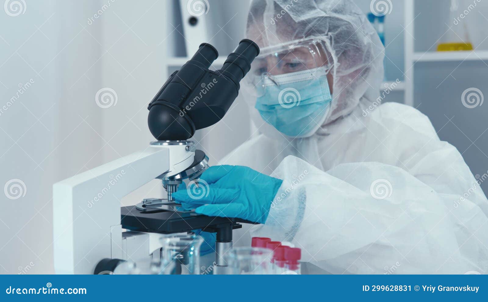 A Scientist in the Laboratory Examines the Microcosm Under a Microscope, Collecting Data for in ...