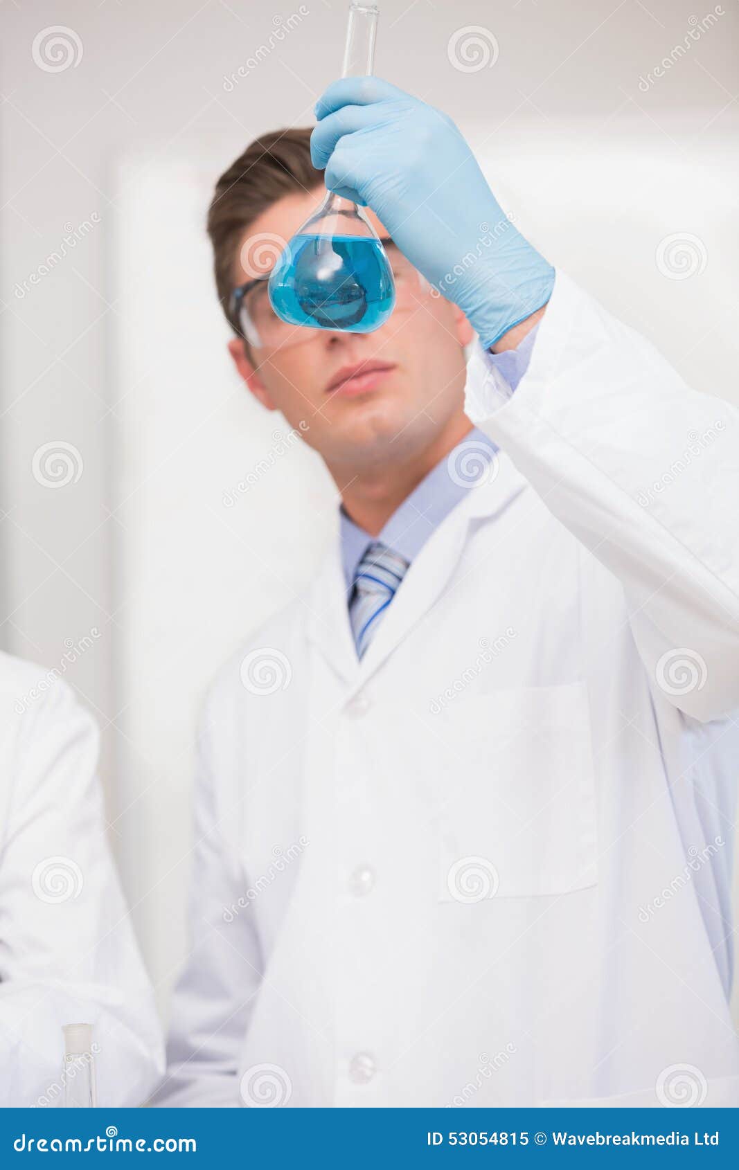 Scientist Looking at Beaker with Blue Fluid Stock Image - Image of ...