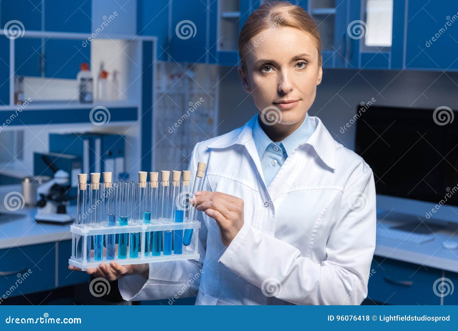 Scientist Looking at Camera and Holding Tubes with Reagents Stock Photo ...