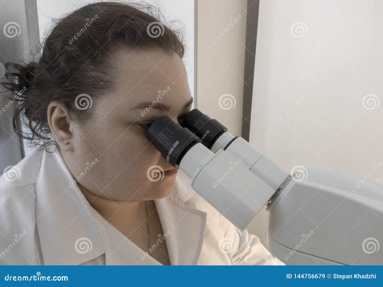 Scientist Looking through a Microscope in a Laboratory Doing Research ...