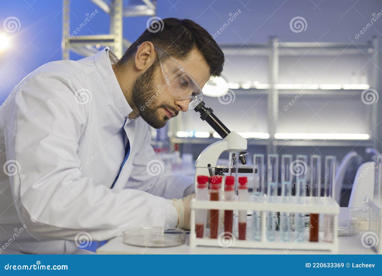 Scientist Looking at Sample Under Microscope in Pharma or Microbiology ...