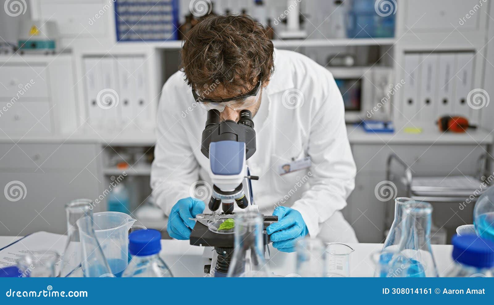 A Scientist Man Examines Specimens Under a Microscope in a Laboratory ...