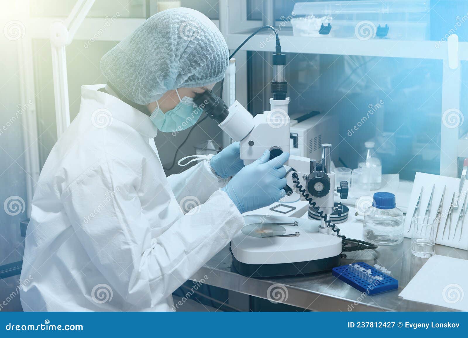 Scientist or Nurse Looking through a Microscope in a Medical Research ...