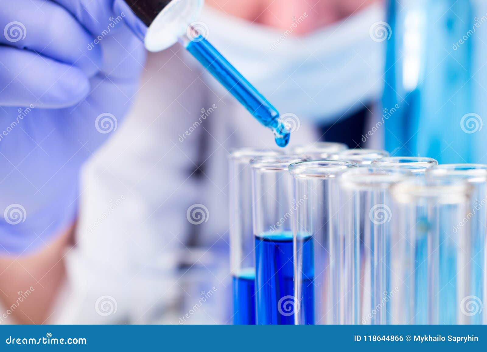 Scientist with Pipette and Test Tubes and Blue Liquid Water Drop Fall ...
