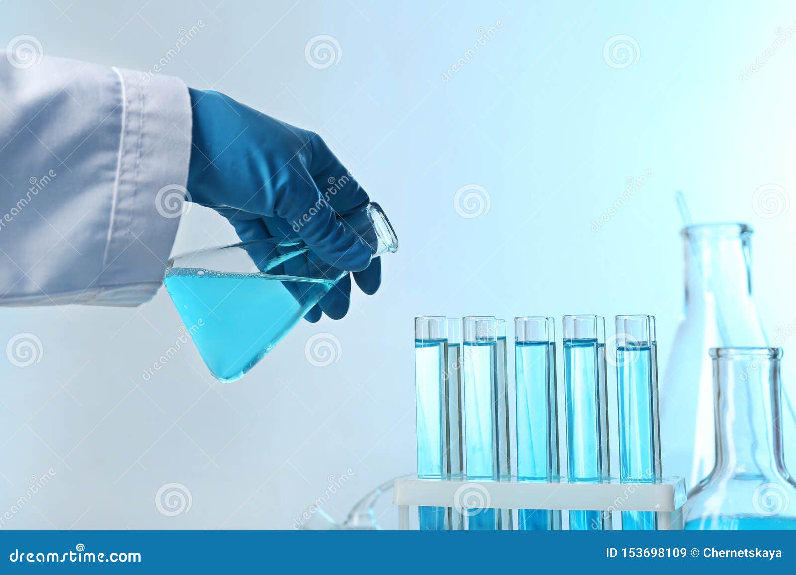 Scientist Pouring Color Liquid from Conical Flask into Test Tubes on ...