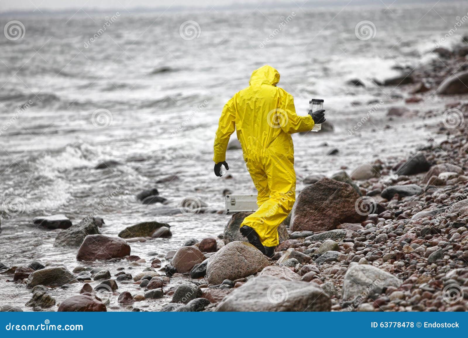 Scientist in Protective Suit with Plastic Container Walking in on Rocky ...