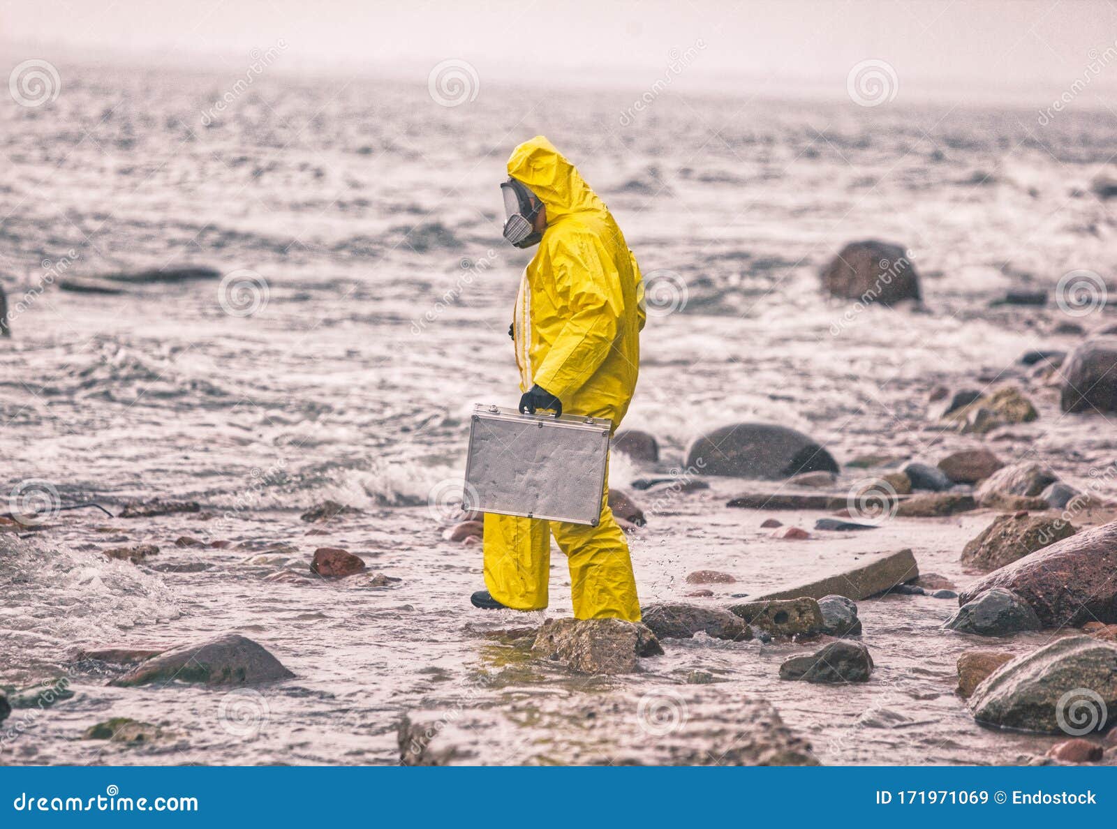 Scientist in Protective Suit with Silver Case Walking on Rocky Beach ...