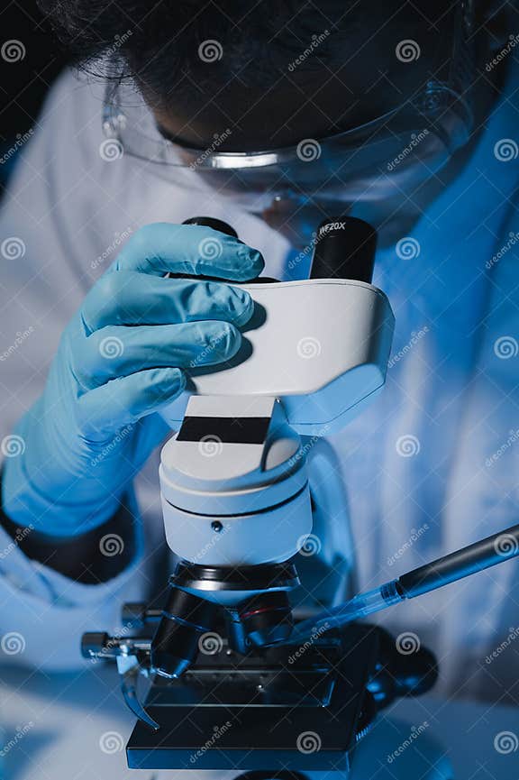 A Scientist is Studying Samples Using a Microscope To Study and Develop the Field of ...
