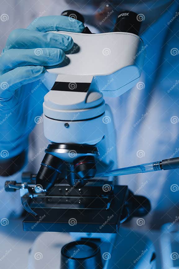 A Scientist is Studying Samples Using a Microscope To Study and Develop ...