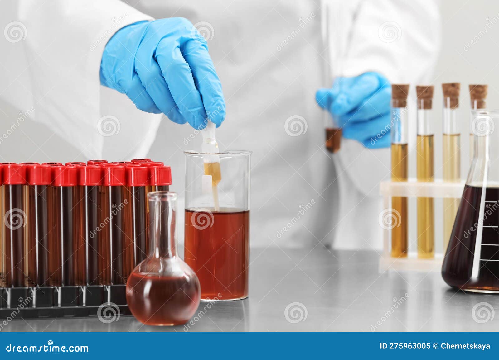 Scientist Taking Brown Liquid with Pipette from Beaker at Table ...