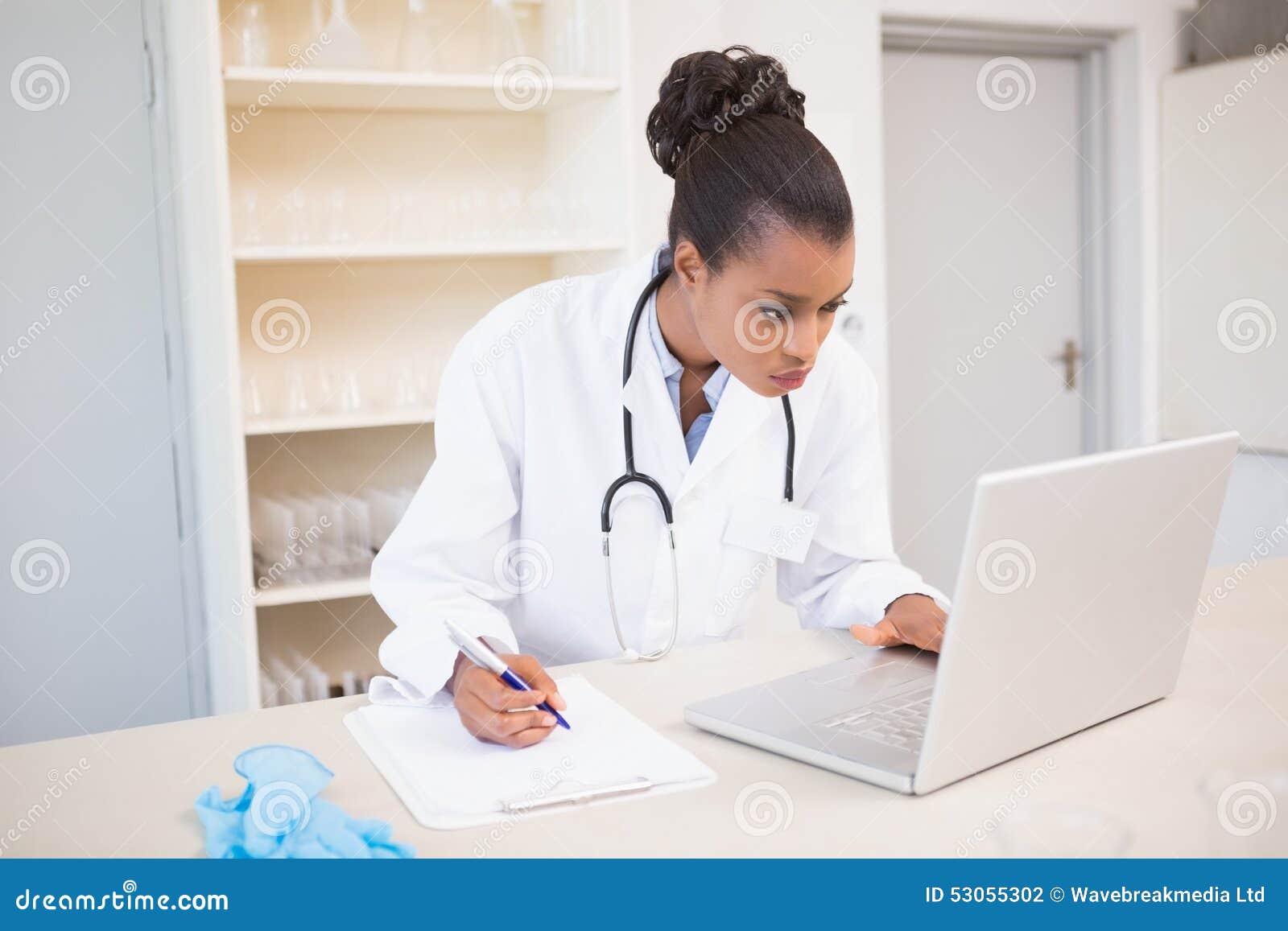 Scientist Taking Notes while Using Laptop Stock Photo - Image of ...