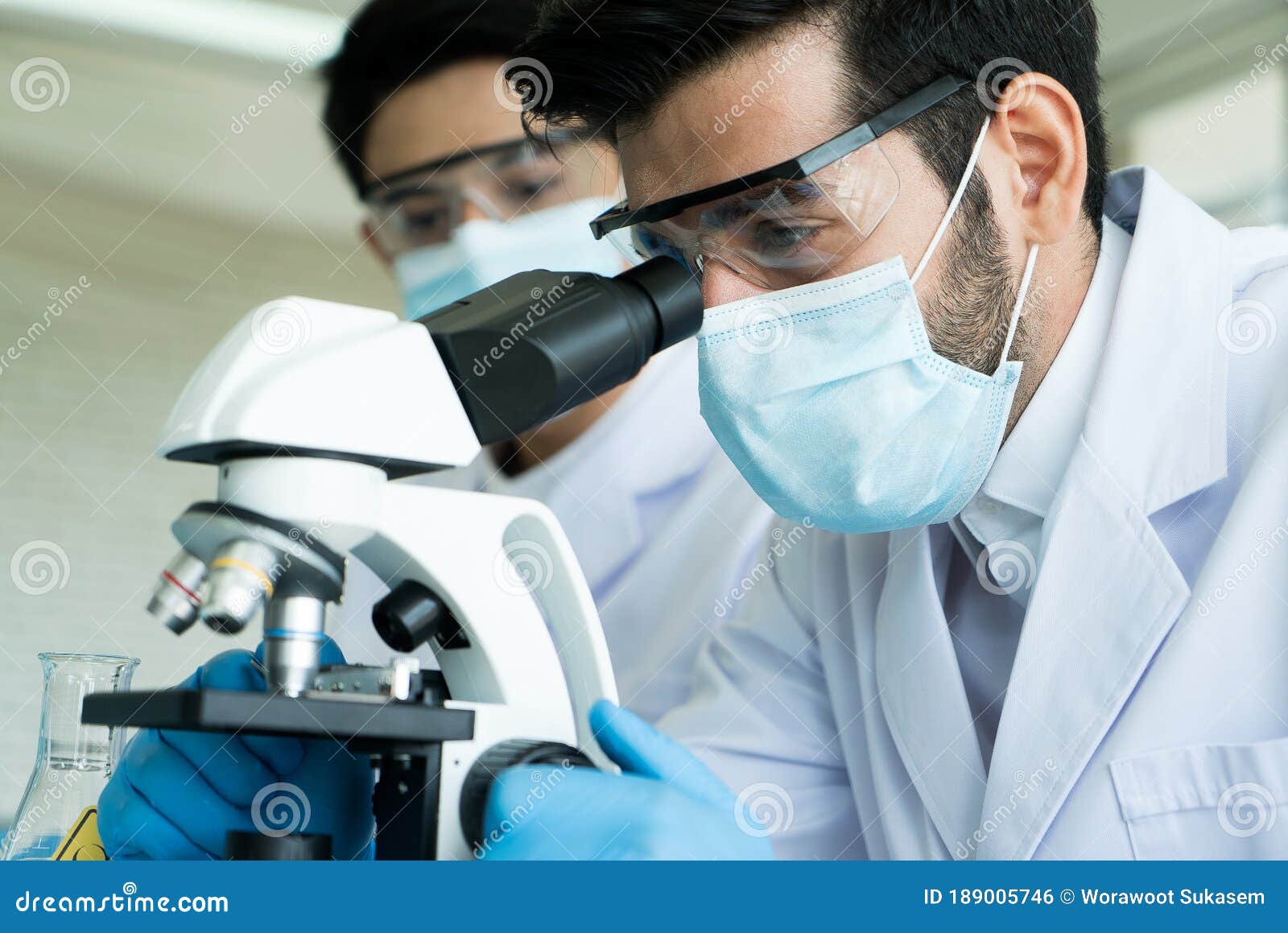 Scientist Team Providing Protection Using Microscope . Stock Photo ...