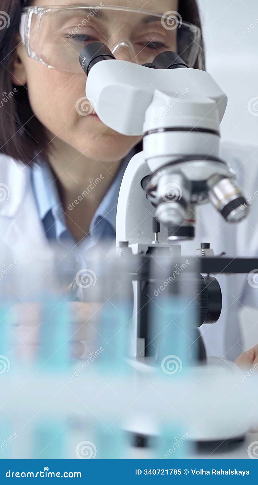 Scientist Using Microscope in Laboratory. Close Up on a Woman Face in ...
