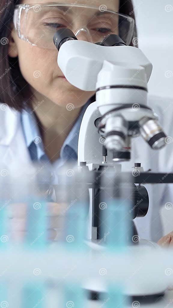 Scientist Using Microscope in Laboratory. Close Up on a Woman Face in ...