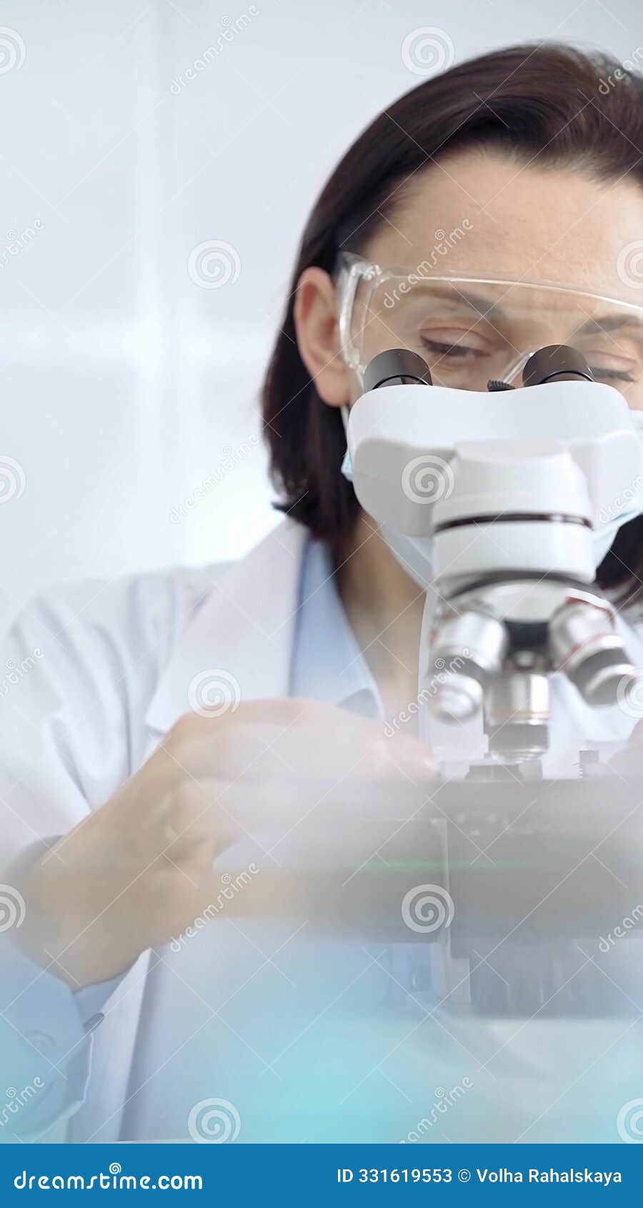 Scientist Using Microscope in Laboratory. Focus on a Woman in Lab ...